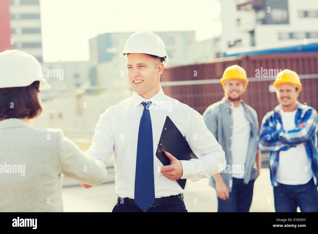 group of smiling builders in hardhats outdoors Stock Photo - Alamy