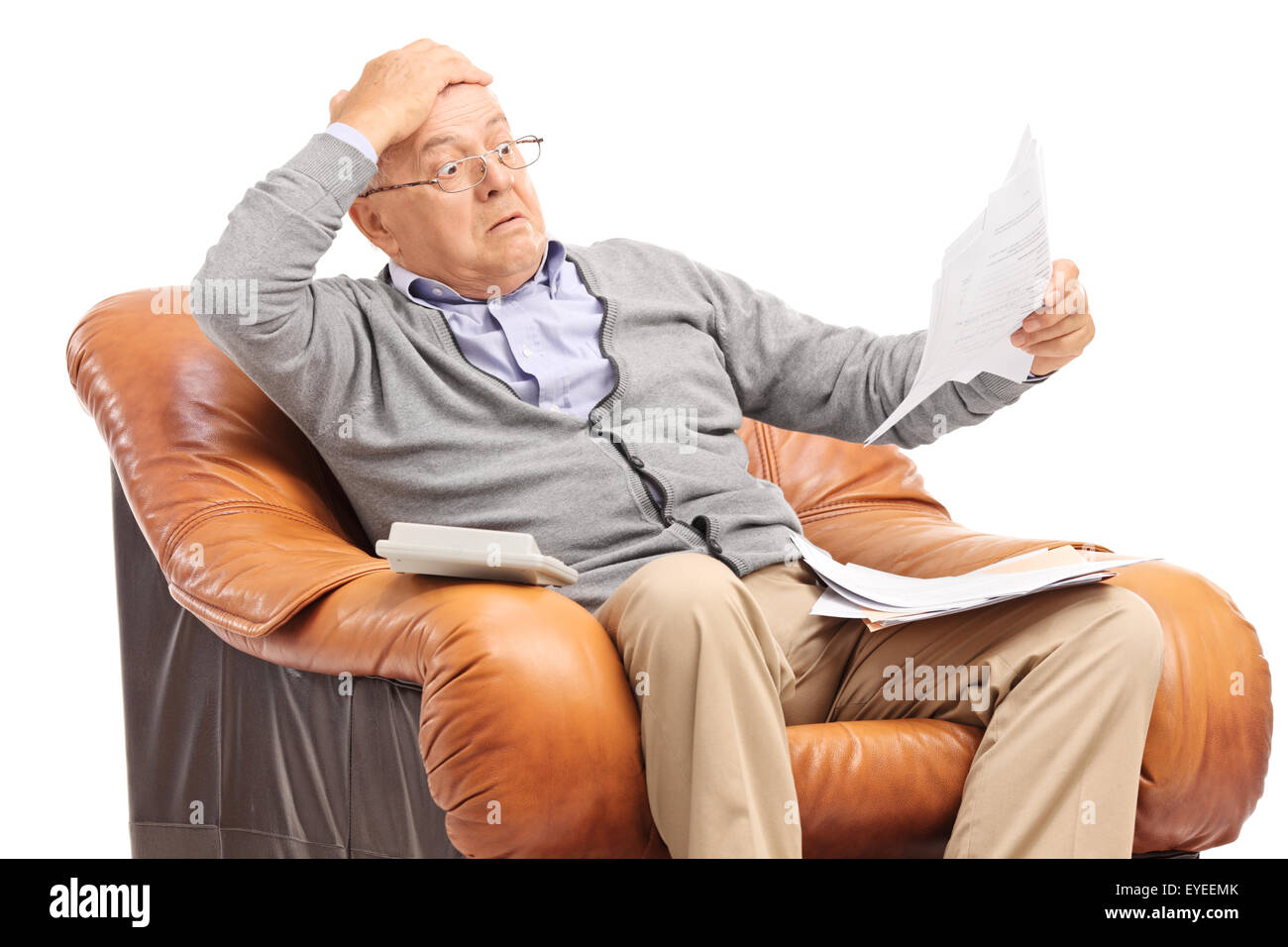 Shocked Senior Gentleman Looking At His Bills In Disbelief Seated In An