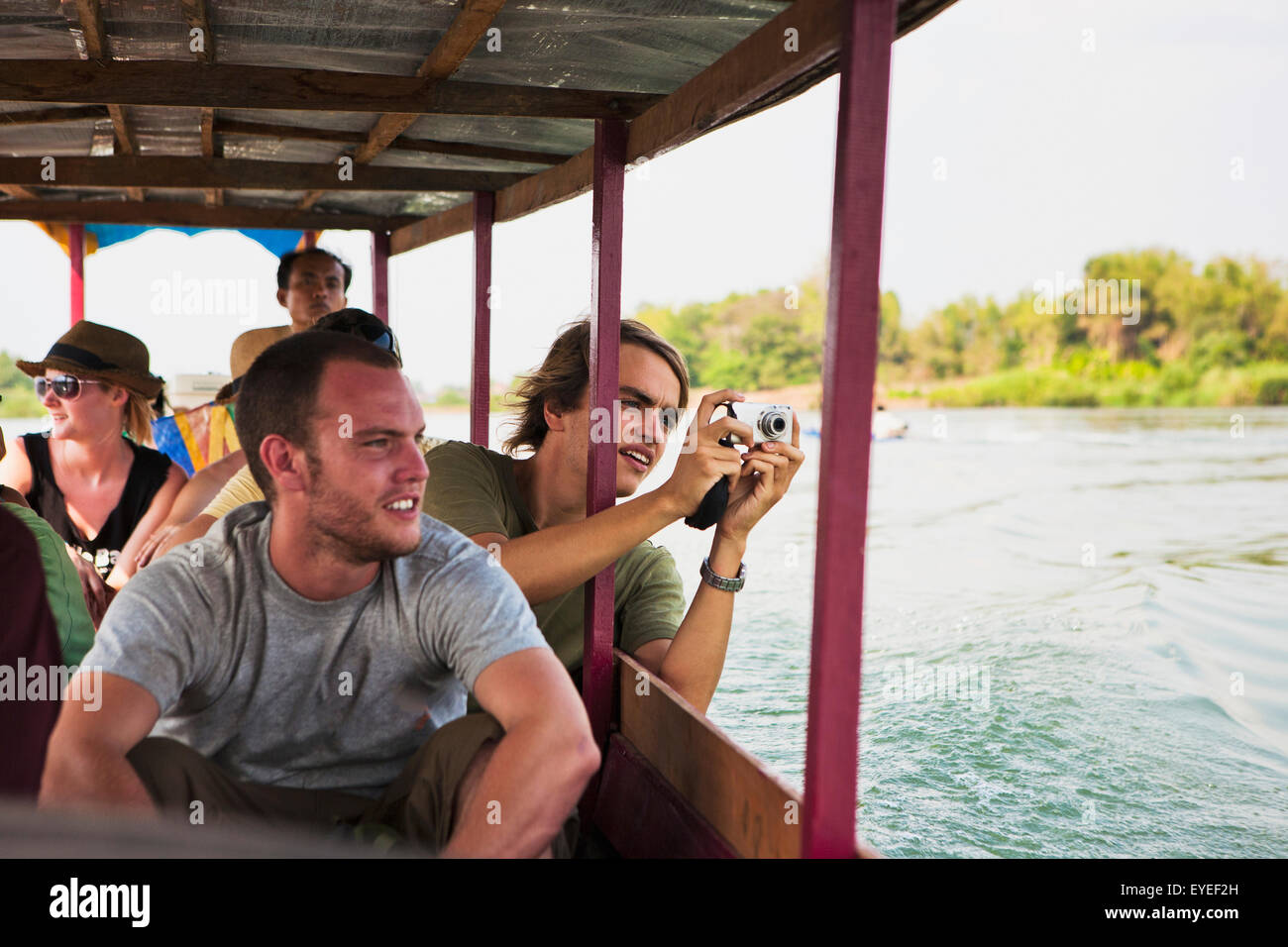 Tourists take a ferry on the Mekong River to the Island of Don Det ...