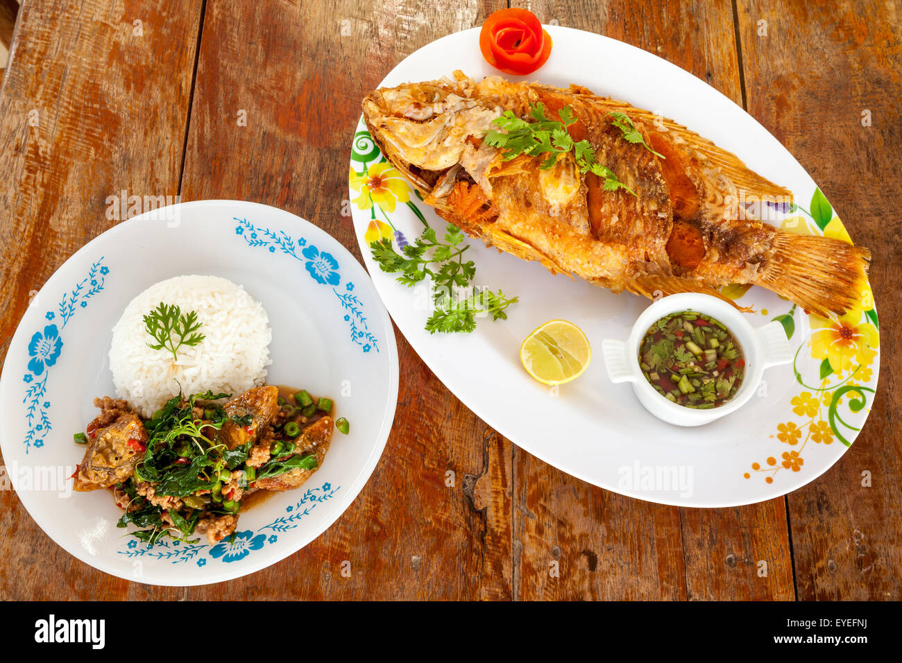 Thai fried fish and cooked on a plate with lemon and the peel of an ...