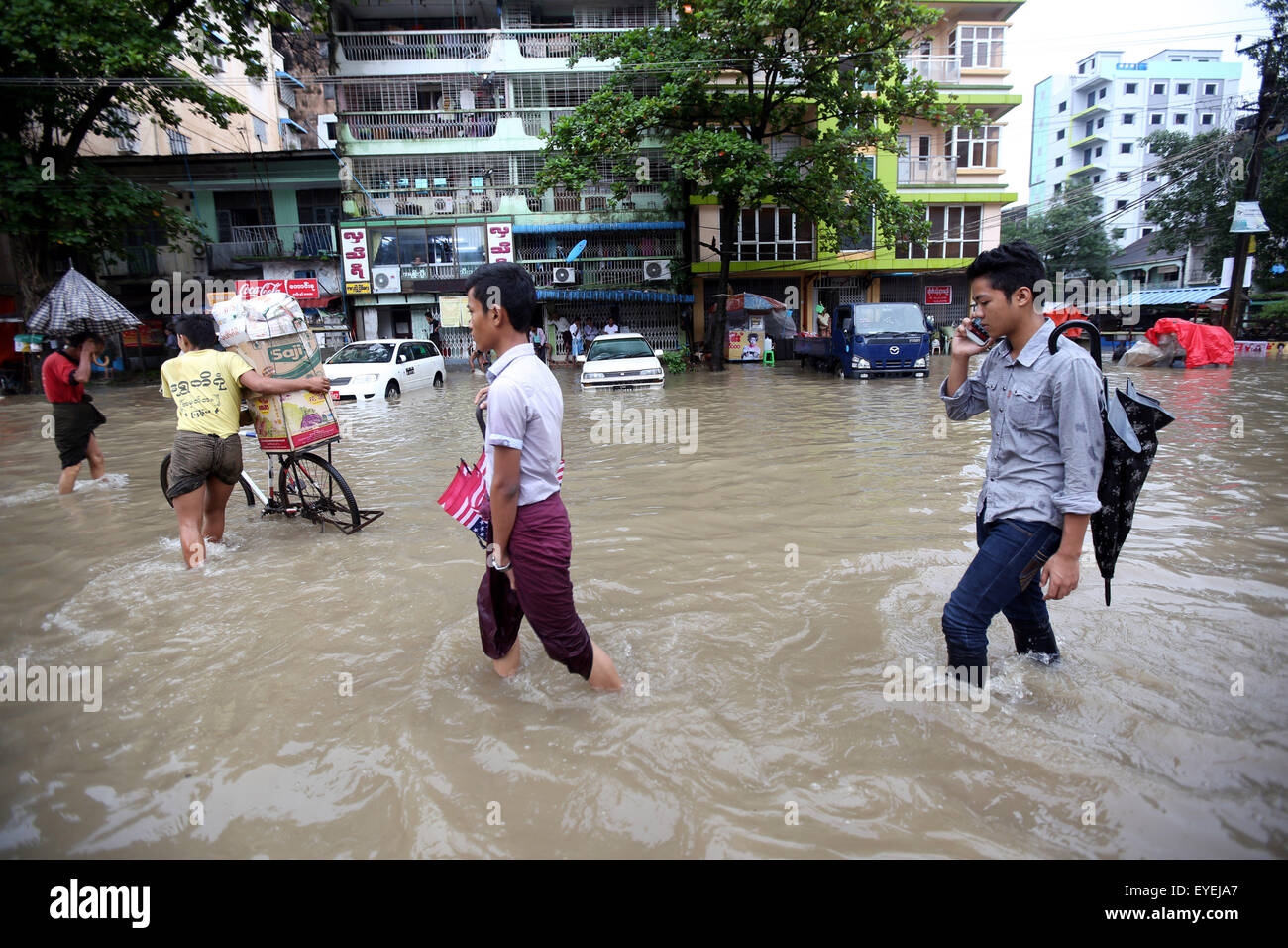 Yangon, Myanmar. 28th July, 2015. People wade through a flooded area in ...
