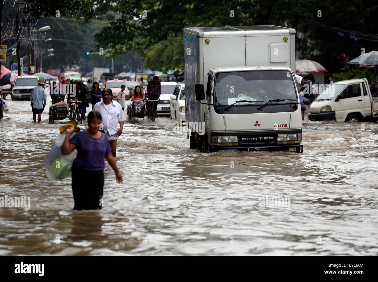 Yangon, Myanmar. 28th July, 2015. People wade through a flooded area in ...