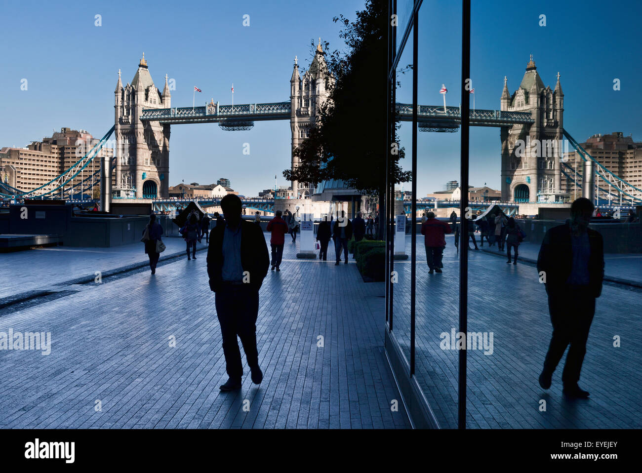 Pedestrians on a walkway with London's tower bridge in the background ...
