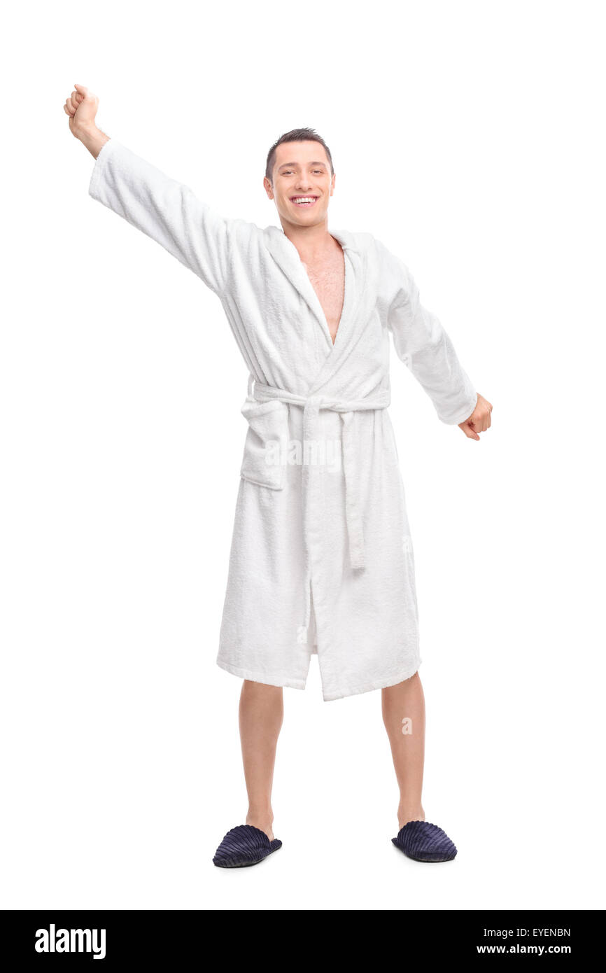 Full length portrait of a cheerful young guy in a white bathrobe ...