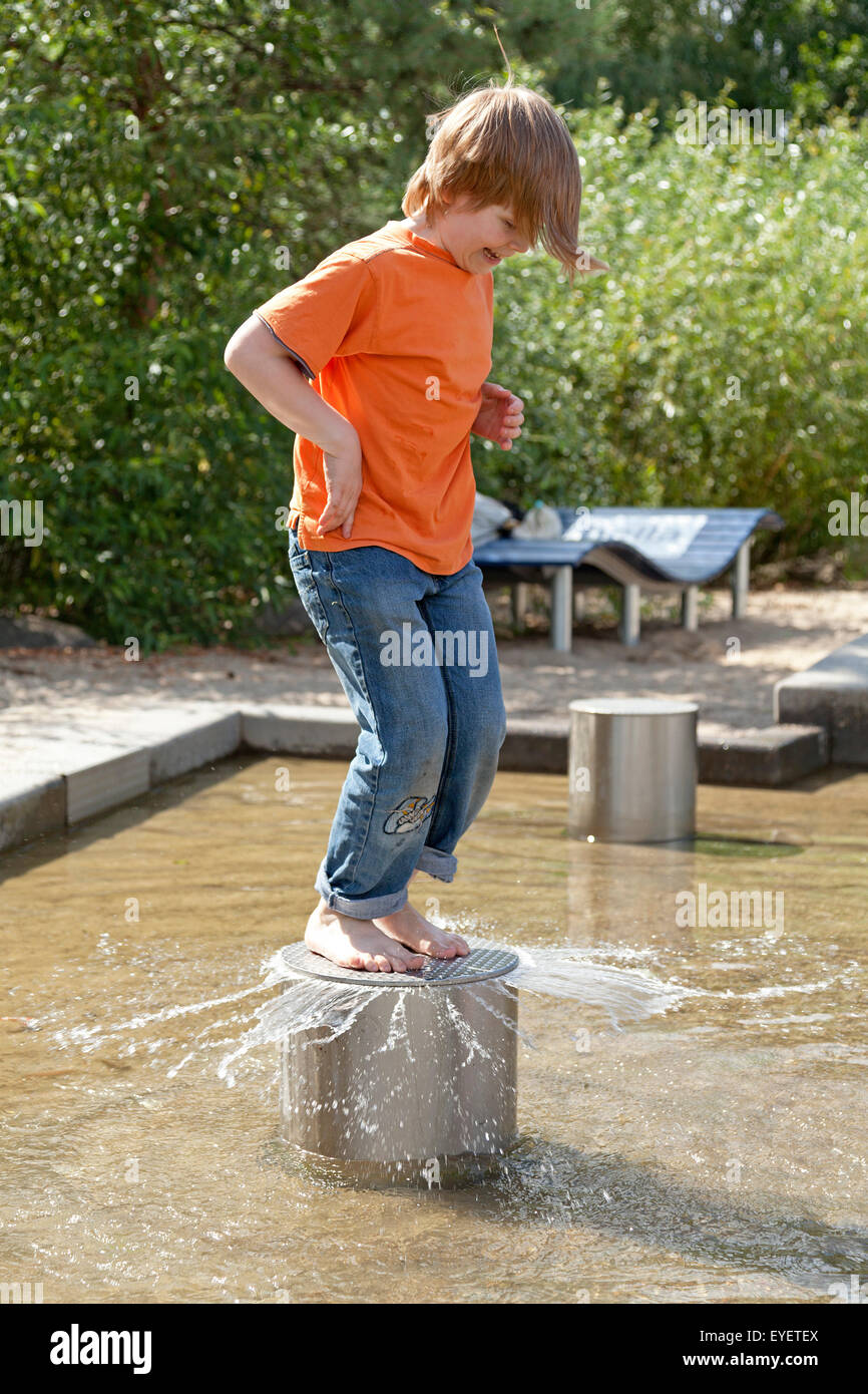 young boy splashing water on a playground Stock Photo - Alamy