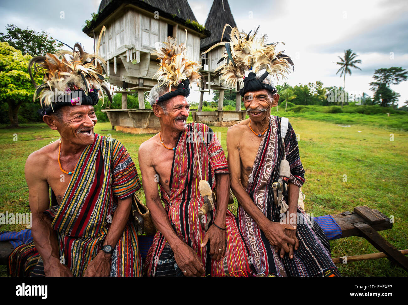 Group of men in traditional attire share a laugh with sacred houses in ...