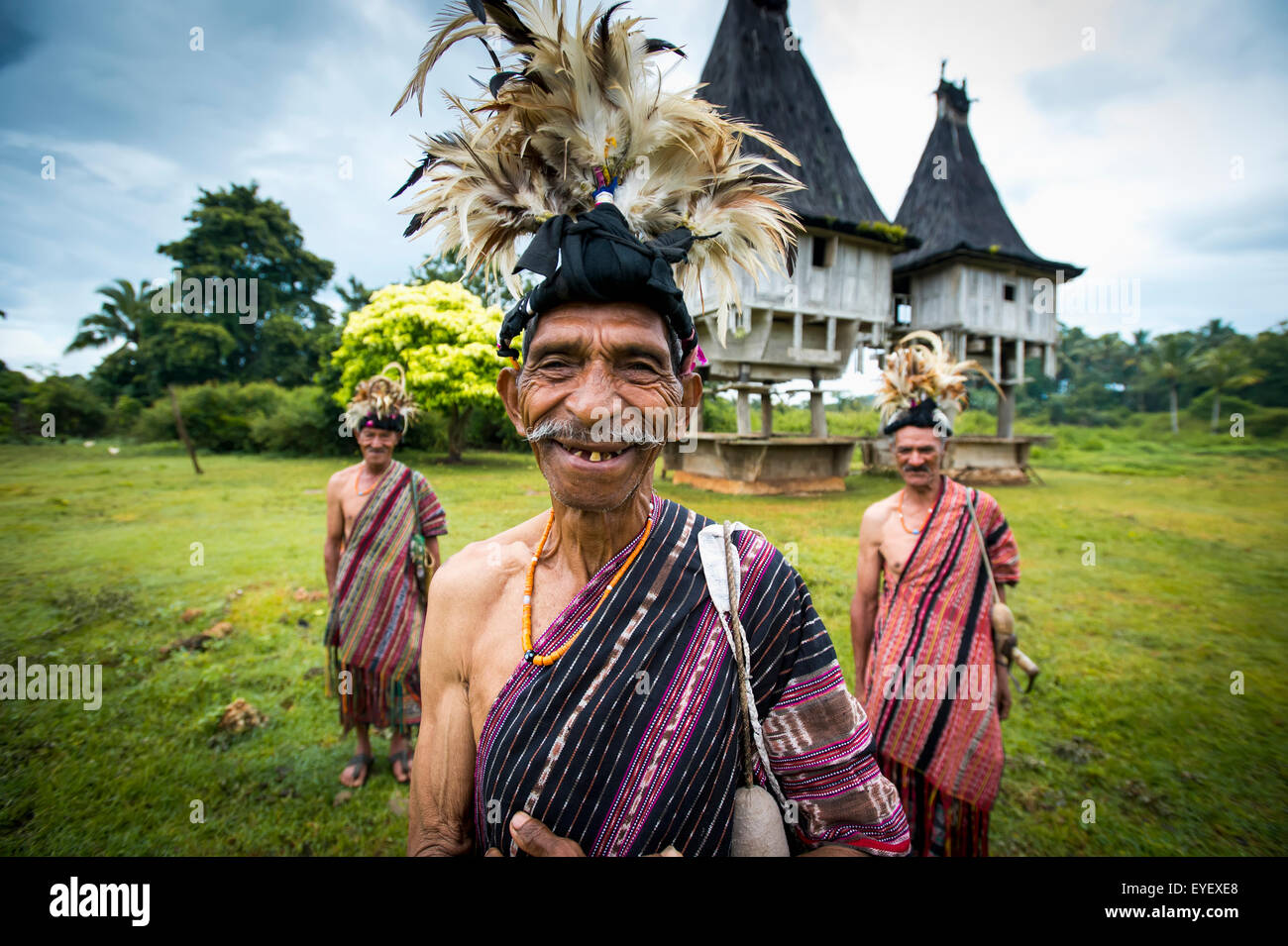 Group of men in traditional attire with sacred houses in the background ...