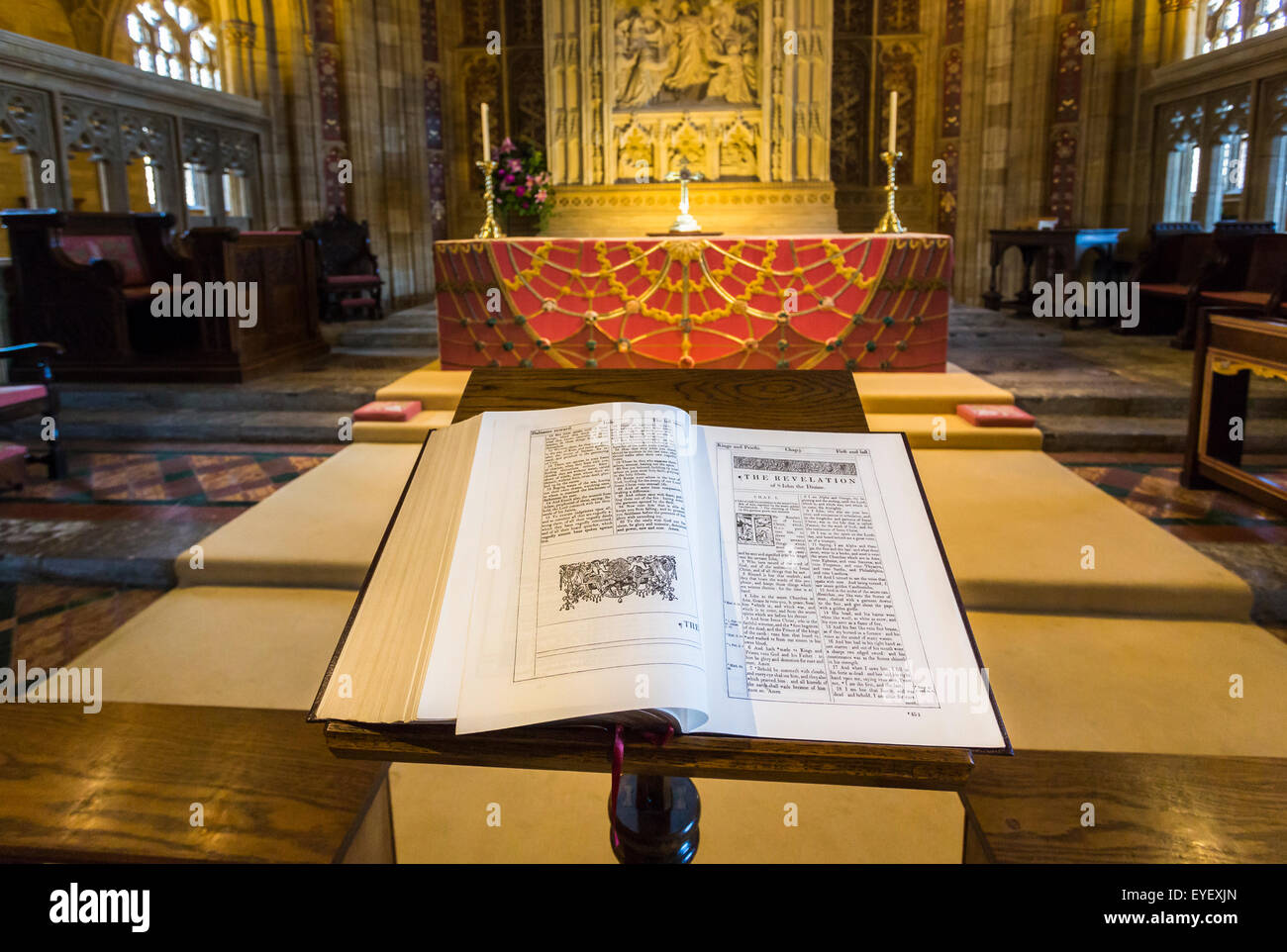 The Holy Bible on a lectern open at the book of Revelation in front of ...