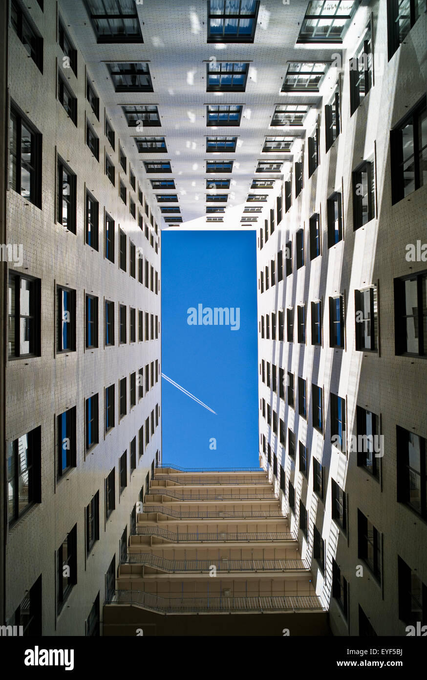 An airplane flying in a blue sky and seen from the ground up the walls ...