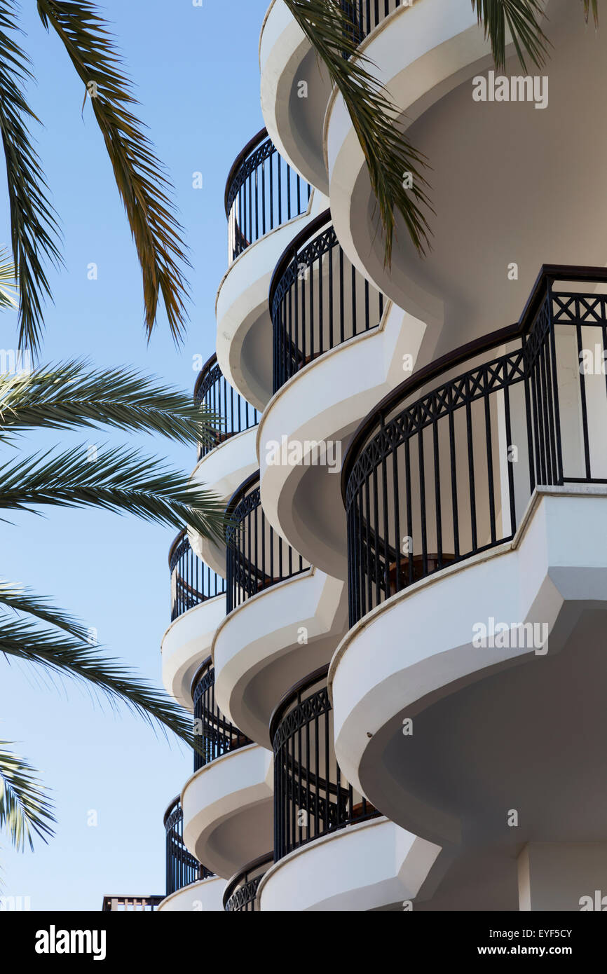 Rounded balconies on a residential building with palm fronds and blue ...