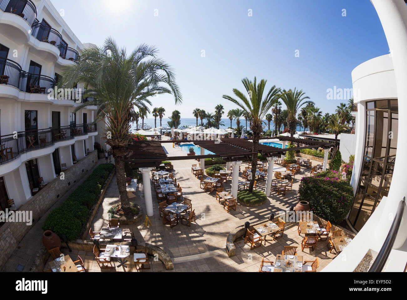 Seating on a patio with palm trees and a view of the mediterranean ...