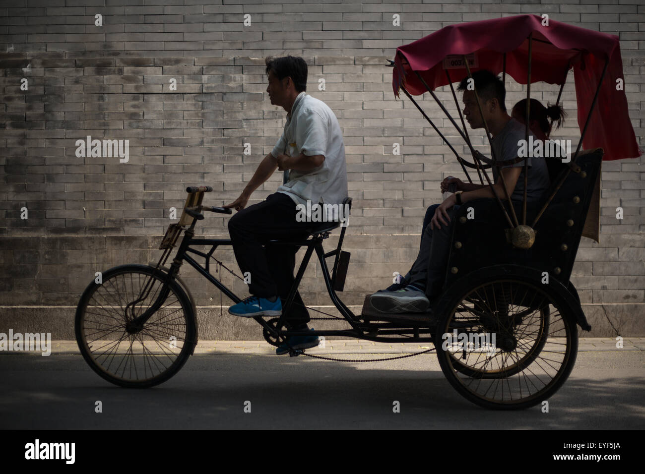 Rickshaw with tourists in Yandai Xiejie hutong area and HouHai Lake, in ...