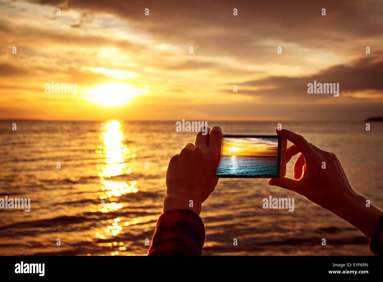 hands holding mobile phone at sunset Stock Photo - Alamy