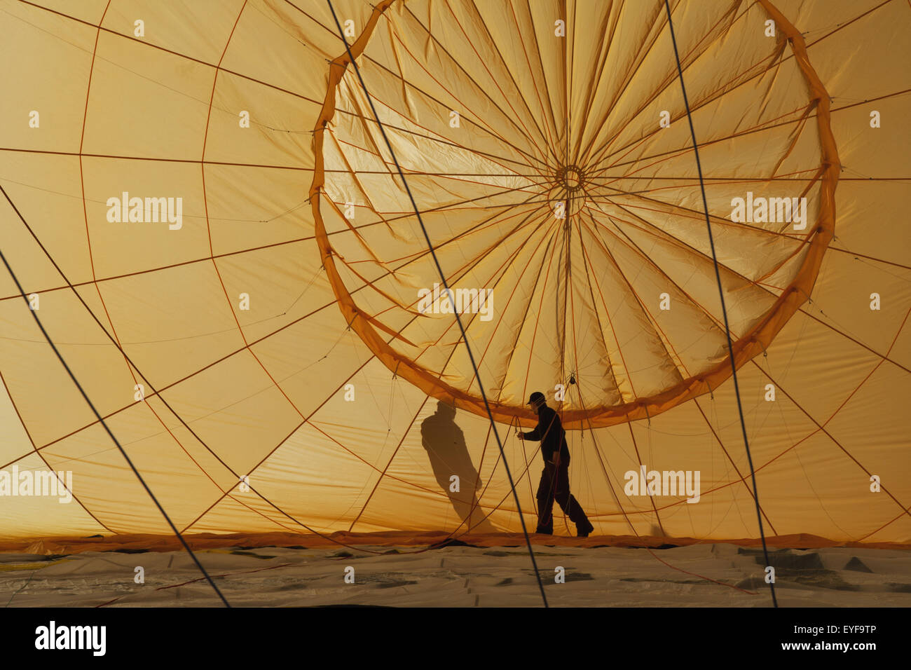 A man checks ropes inside a hot air balloon as it lies on the ground ...