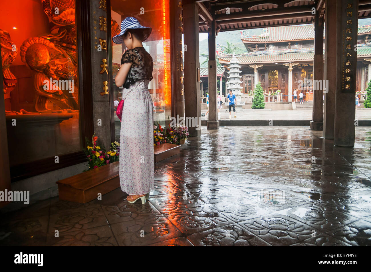 A young woman praying in Nan Pu Tuo Temple to the Buddhist Guardians ...