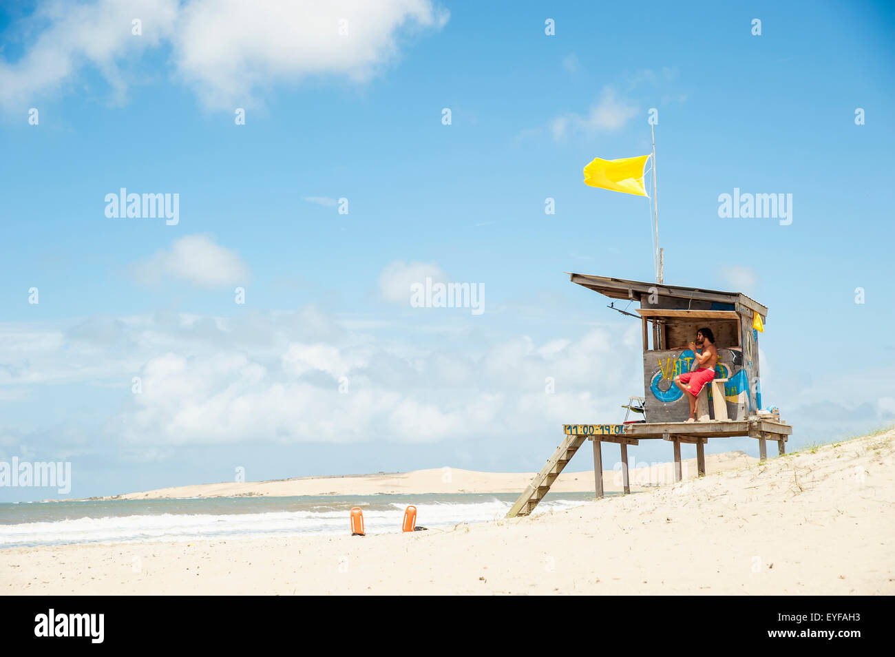 Lifeguard on duty at a lifeguarding station with a yellow flag; Valizas ...