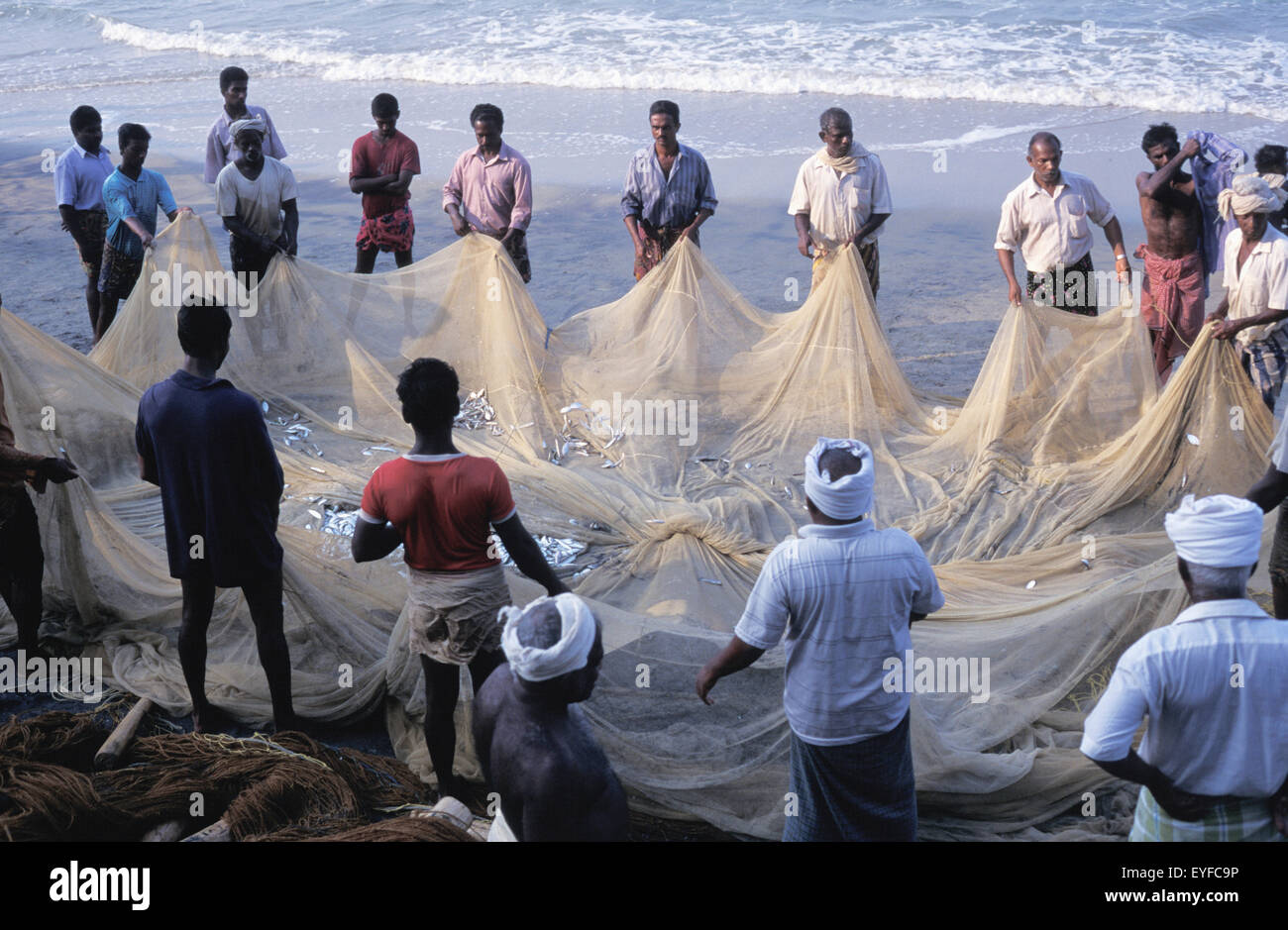 Group Of Fishermen Working On Beach Stock Photo - Alamy