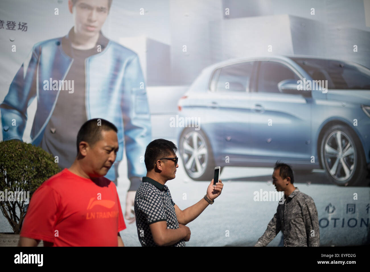 Chinese men in front of car advertising billboards, In Qianmen Street ...