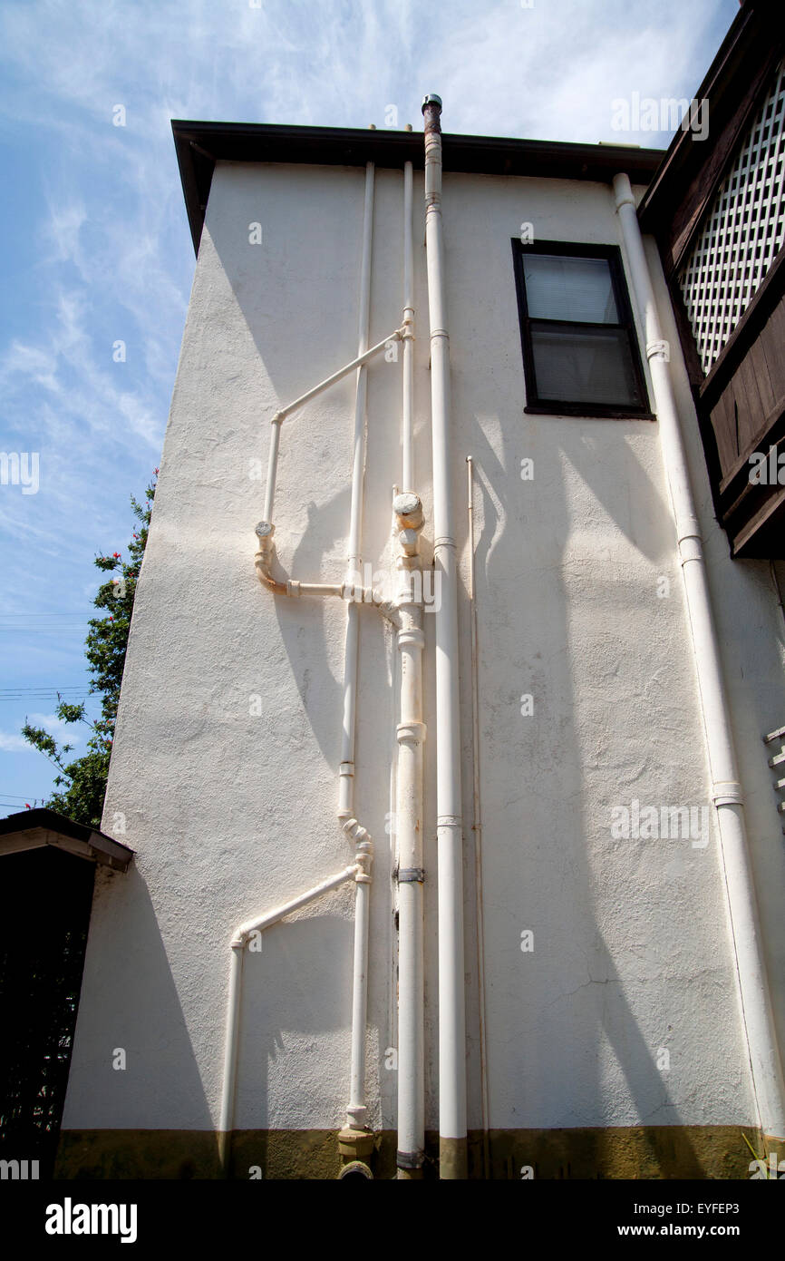 A complex system of external pipes serves the plumbing needs of an old ...