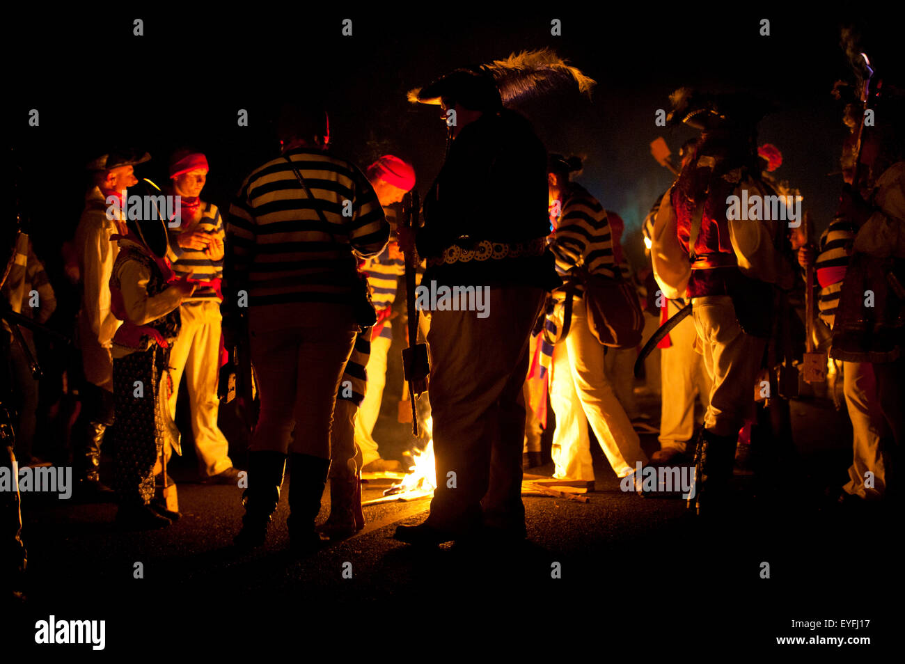 People collecting around small fire during a break in procession at ...