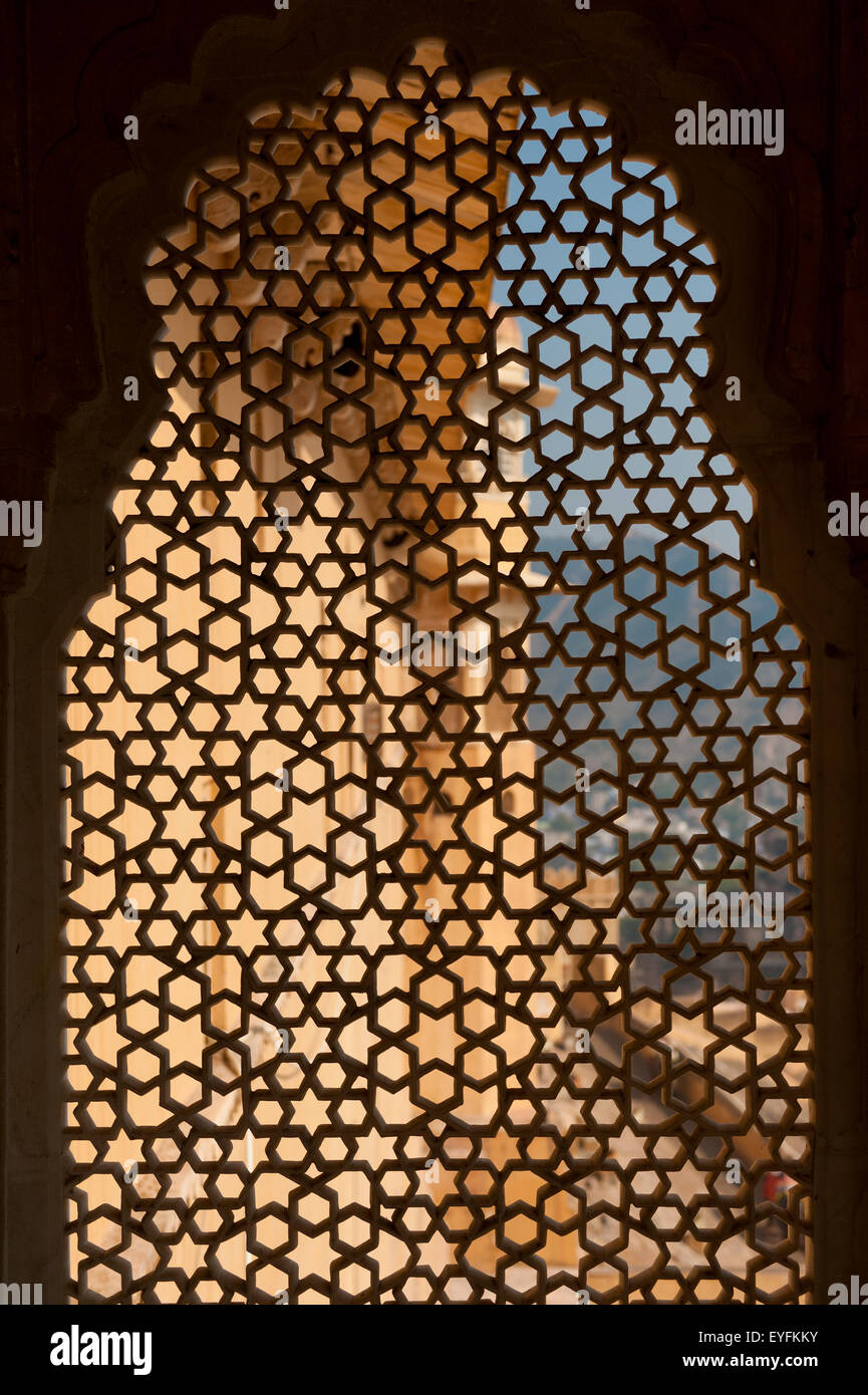 Looking through stone lattice window to the walls of Amber Fort; Amer ...