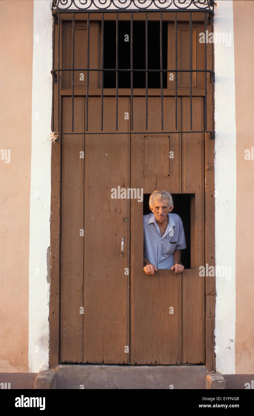 Man looking out window of wooden door; Trinidad, Cuba Stock Photo - Alamy