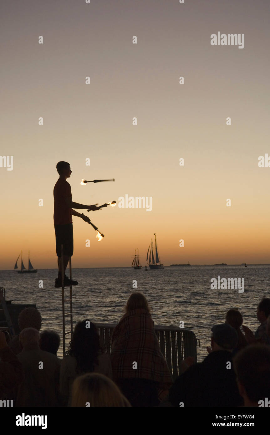 USA, Florida Keys, Juggler using lighted torches entertains crowd who ...