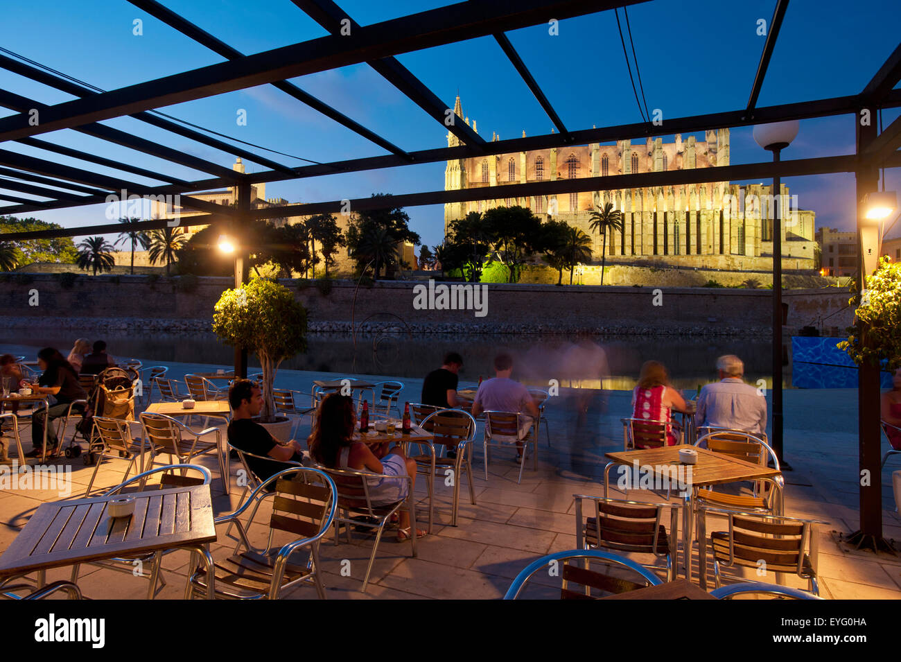 Spain, Majorca, People in cafe beside Parc del Mar with cathedral ...