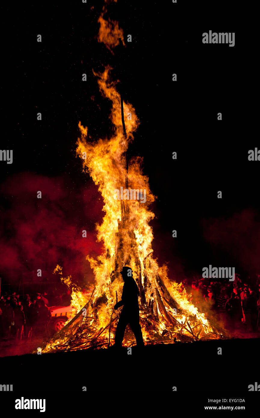 UK, England, Silhouette of man walking past large bonfire at Battle ...
