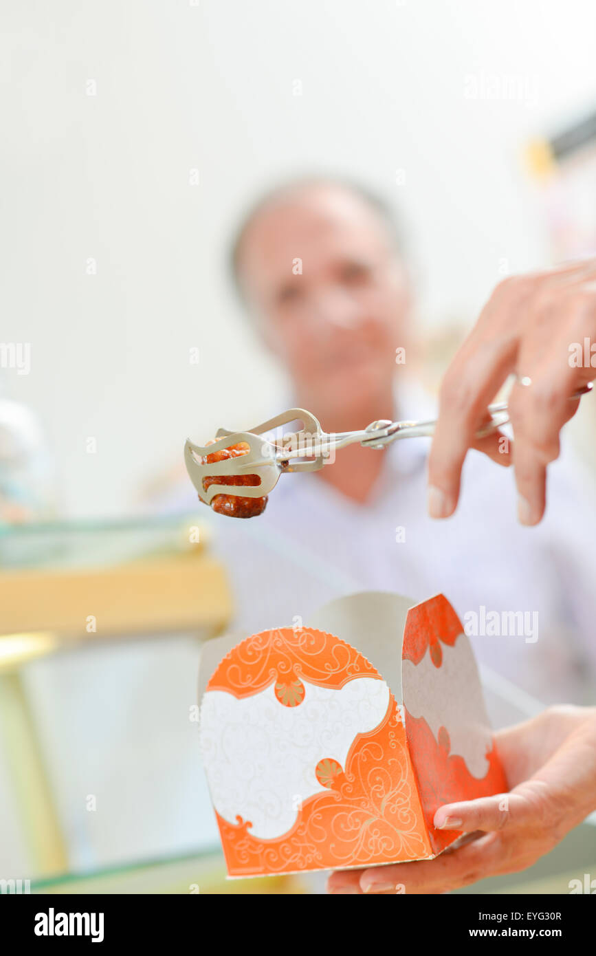 Serving bitesize treats with tongs Stock Photo - Alamy