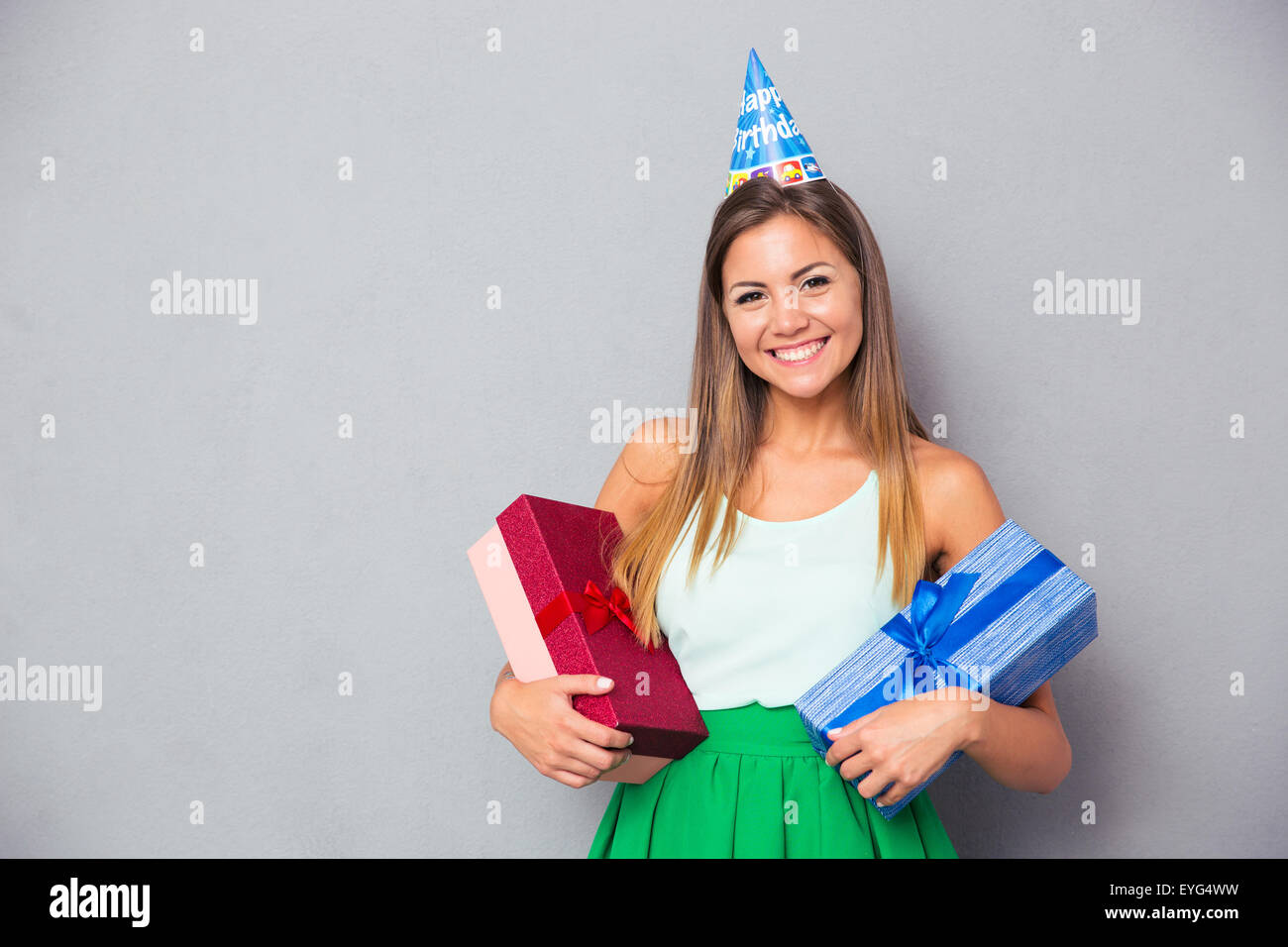 Portrait of a happy beautiful girl celebrating her birthday over gray ...