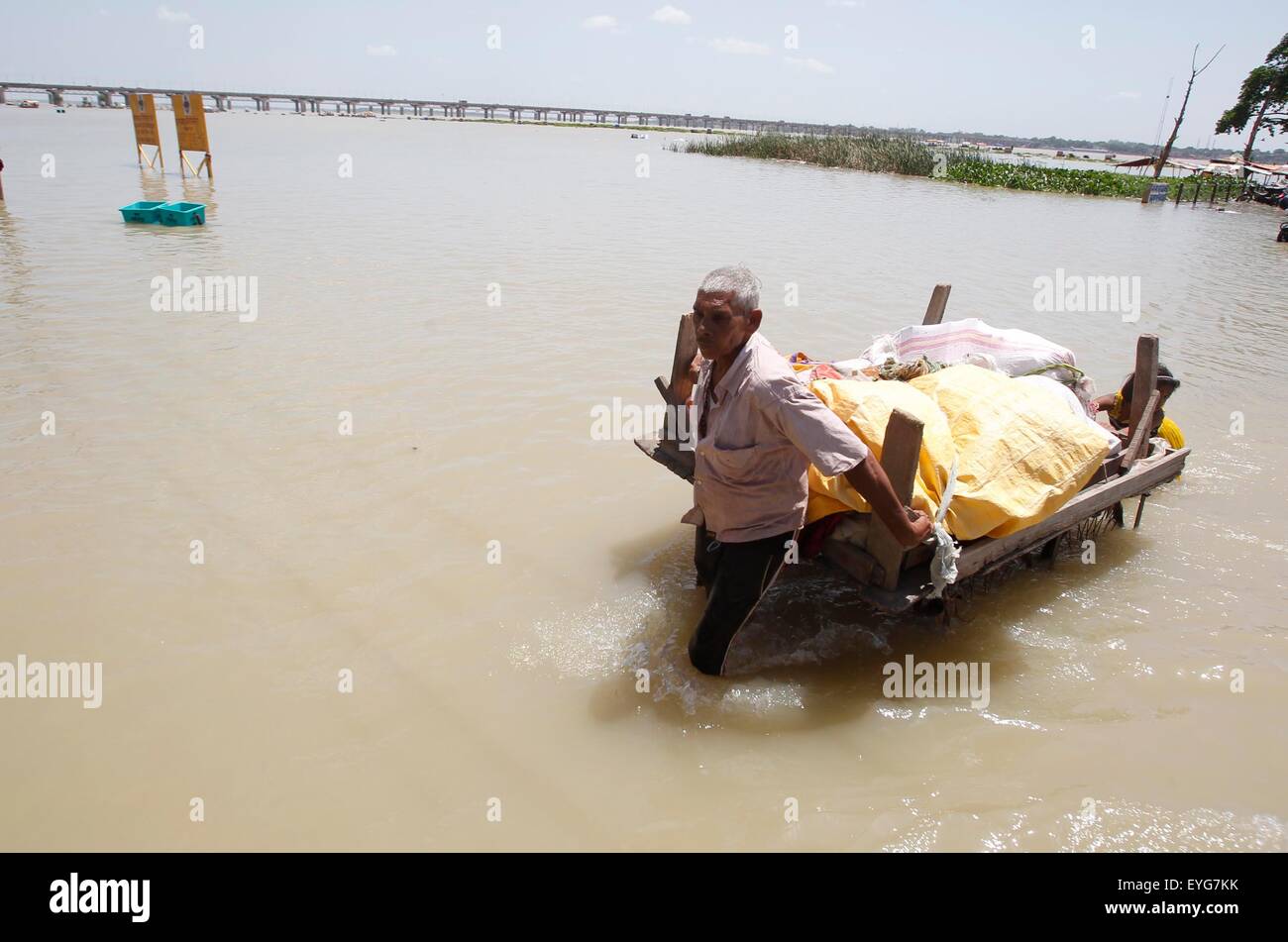 Allahabad, India. 29th July, 2015. A man uses a trolley to transport ...