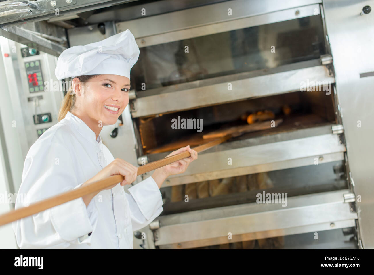 Female baker at bread oven Stock Photo - Alamy