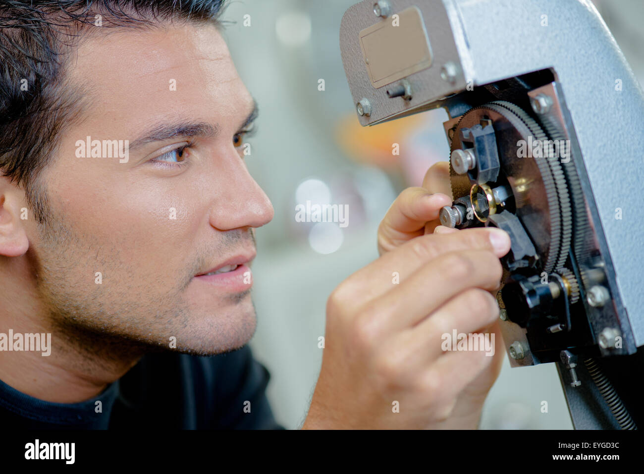 Man adjusting cog Stock Photo - Alamy