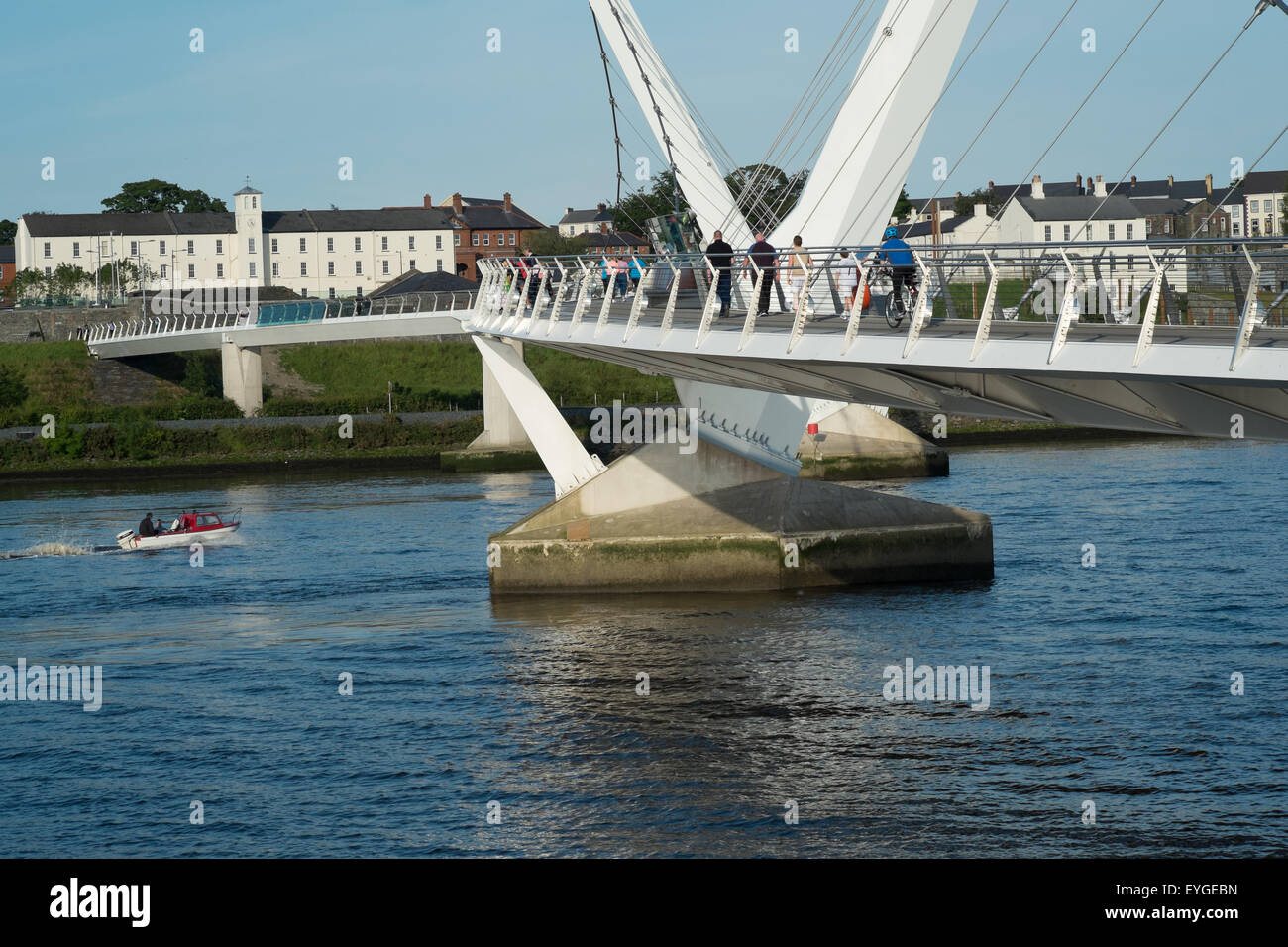 A small boat passes under the Peace Bridge Derry Londonderry Northern ...