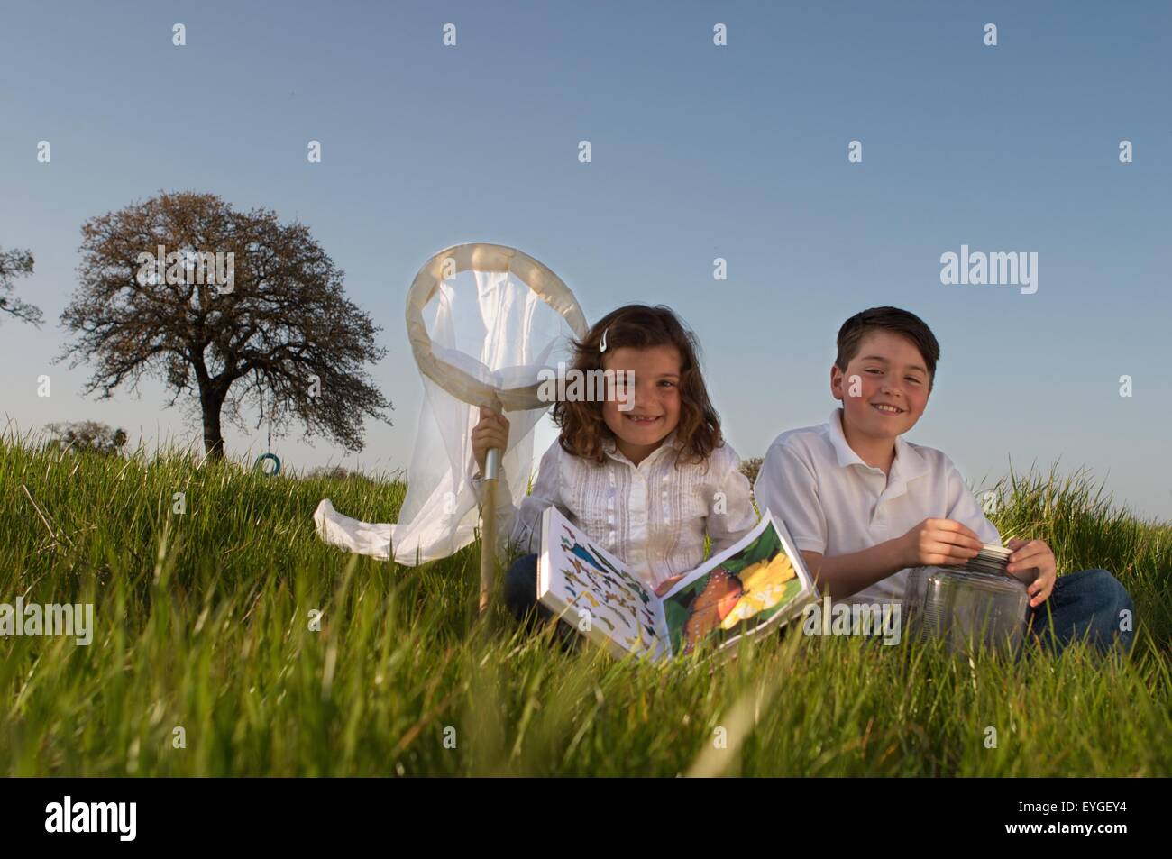 Brother and sister catching butterflies. Learning about Stock Photo - Alamy