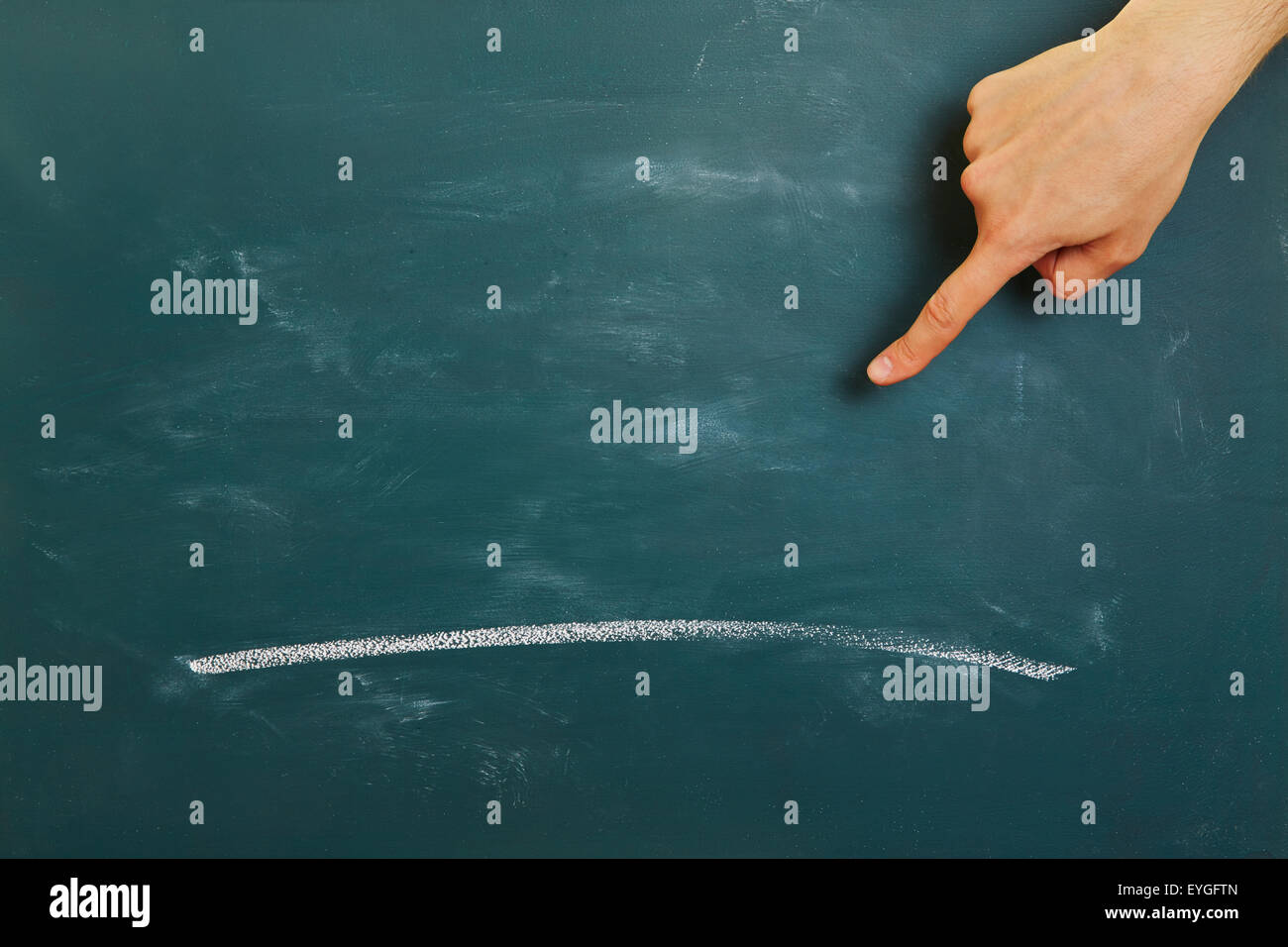 Index finger of a hand pointing to white line on a chalkboard Stock ...