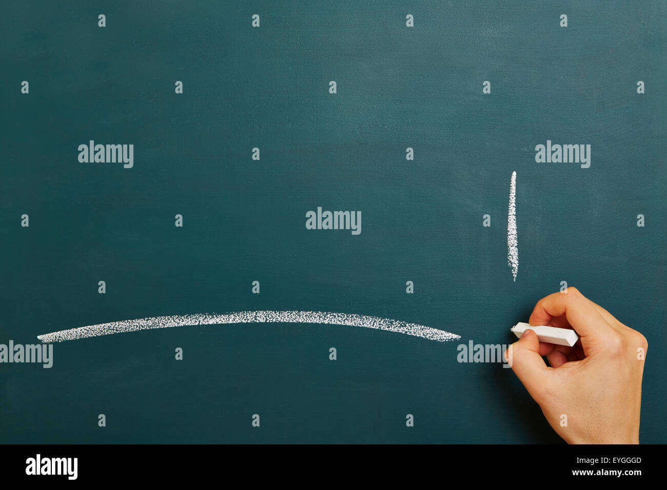 Hand drawing a white chalk line on a chalkboard with explamation mark ...