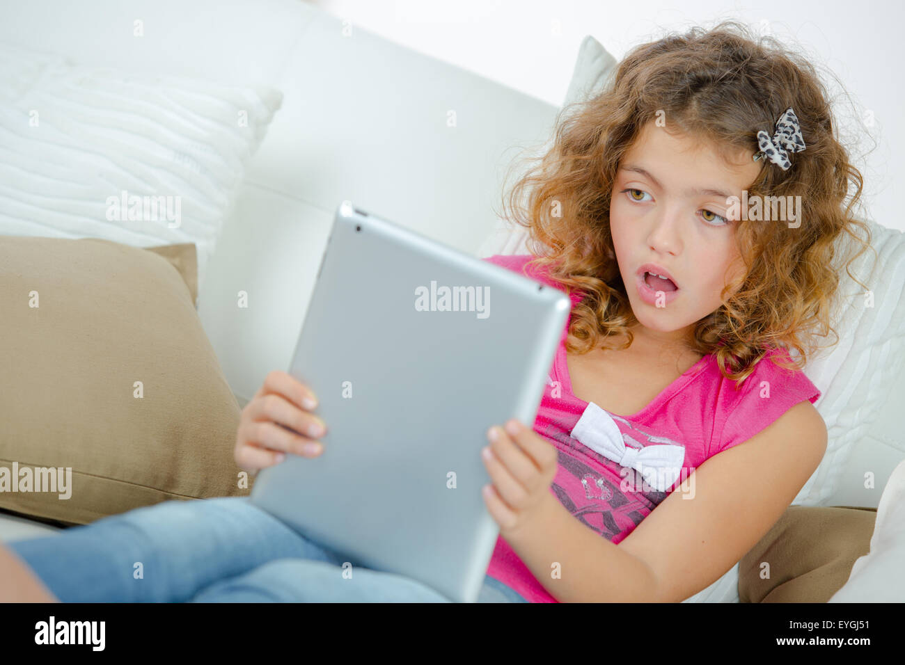 Surprised child looking at tablet Stock Photo - Alamy