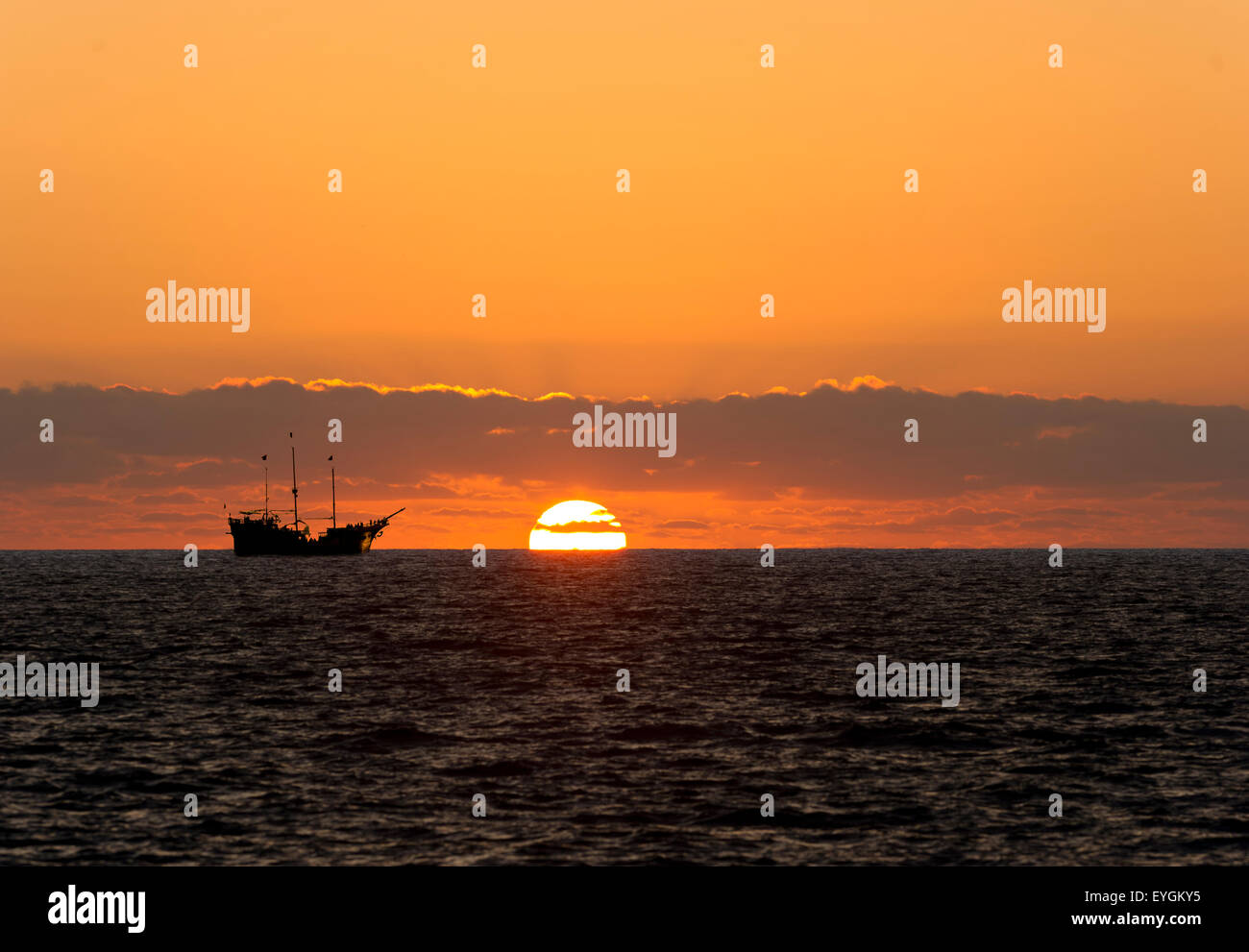 Pirate ship sunset is sailing at sea silhouetted against a setting sun ...