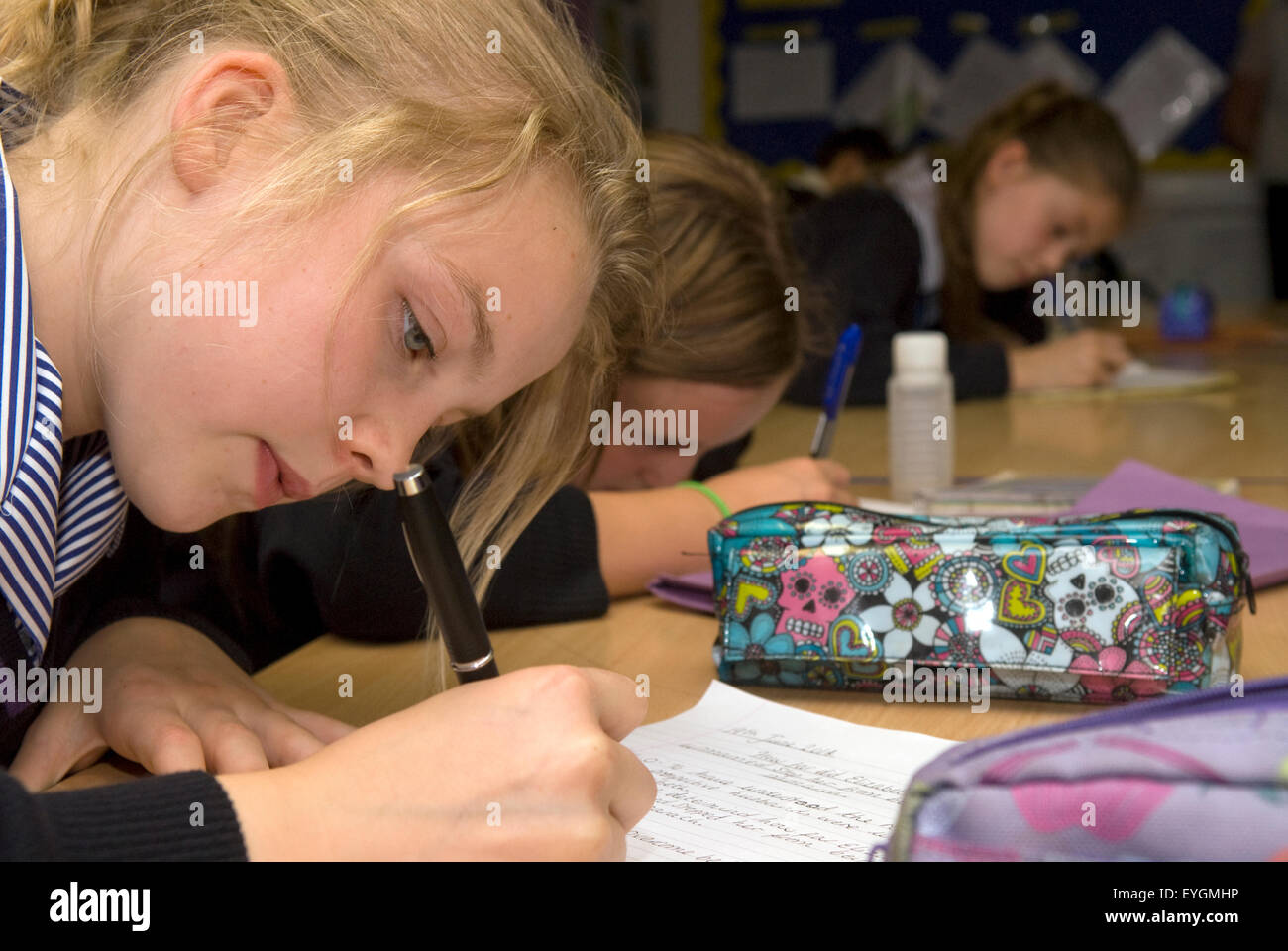 Secondary school pupils studying and writing in classroom, Surrey, UK ...