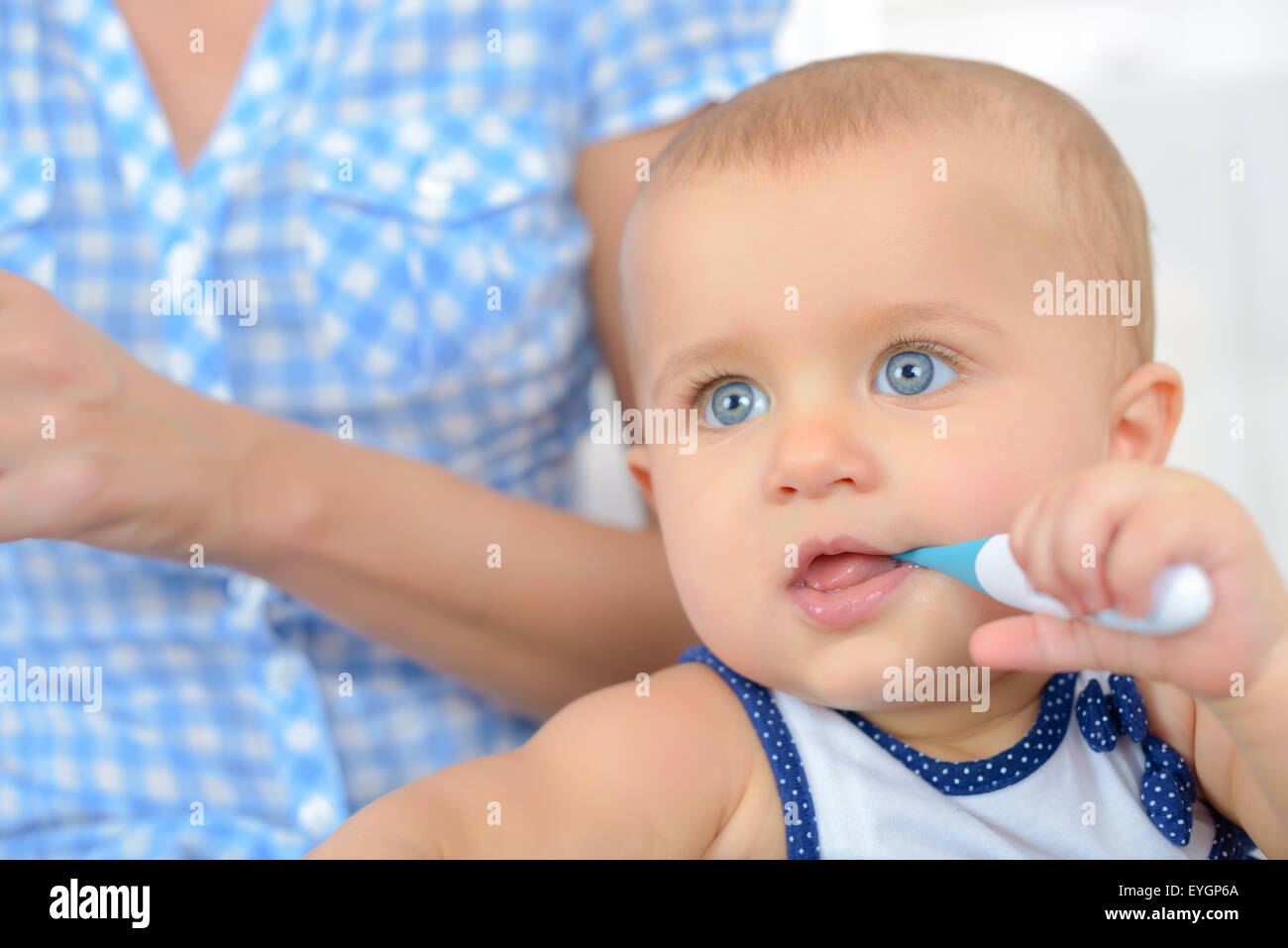 Baby with a spoon in his mouth Stock Photo - Alamy