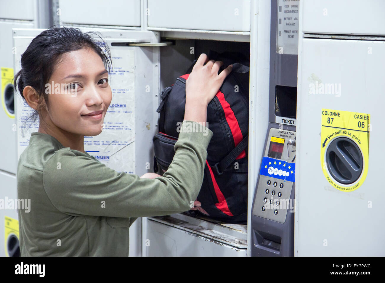 Woman puts backpack to safety locker Stock Photo - Alamy