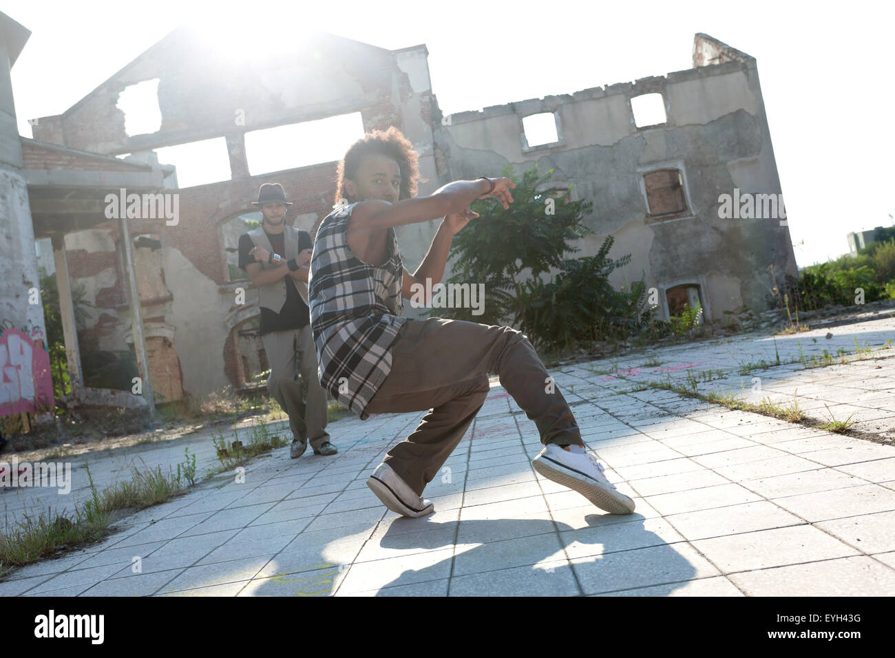 Young African American man hip hop dancing in an urban square with a ...