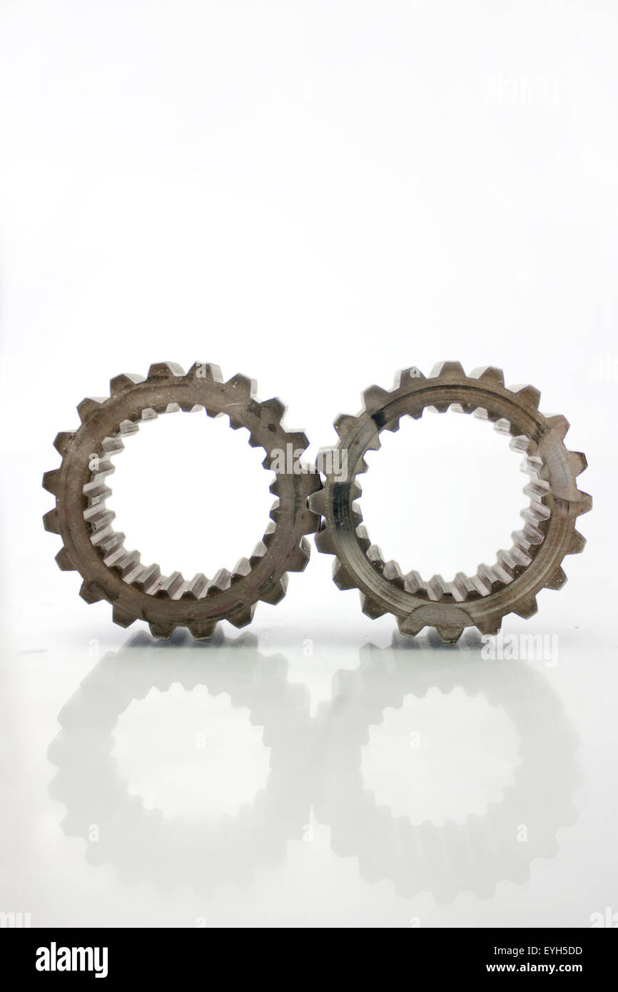 Two gears working well together on a white background and a reflection ...