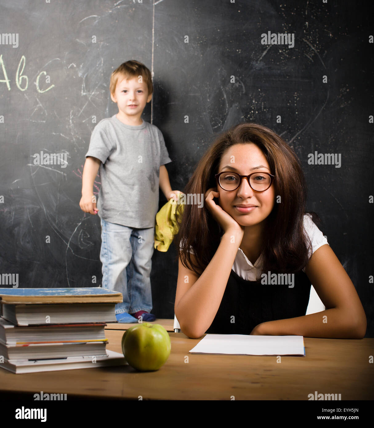 little cute boy in glasses with young real teacher, classroom studying ...