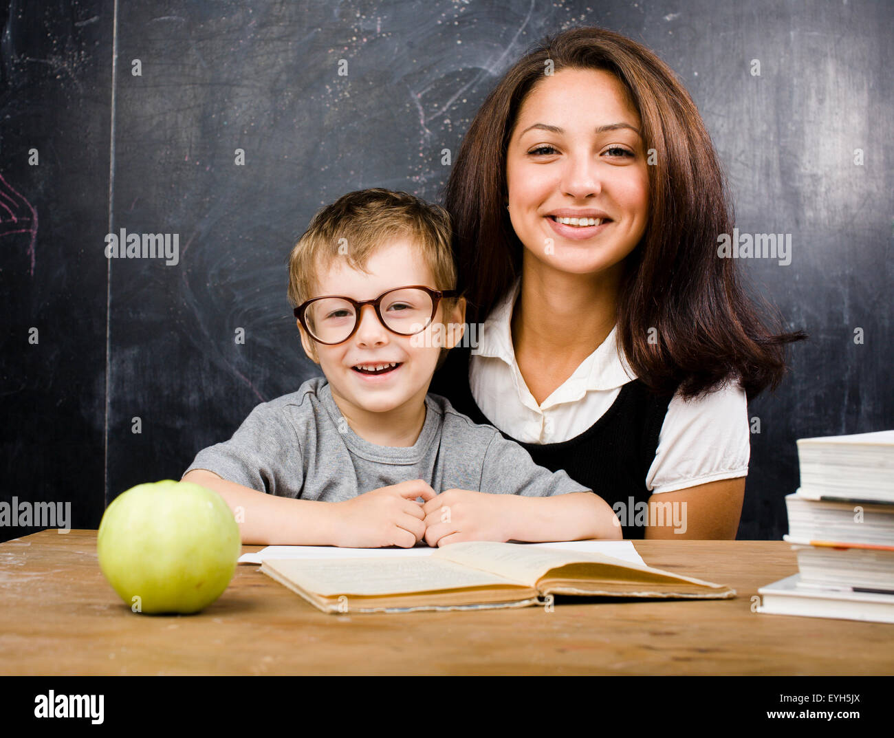 little cute boy in glasses with young real teacher, classroom studying ...