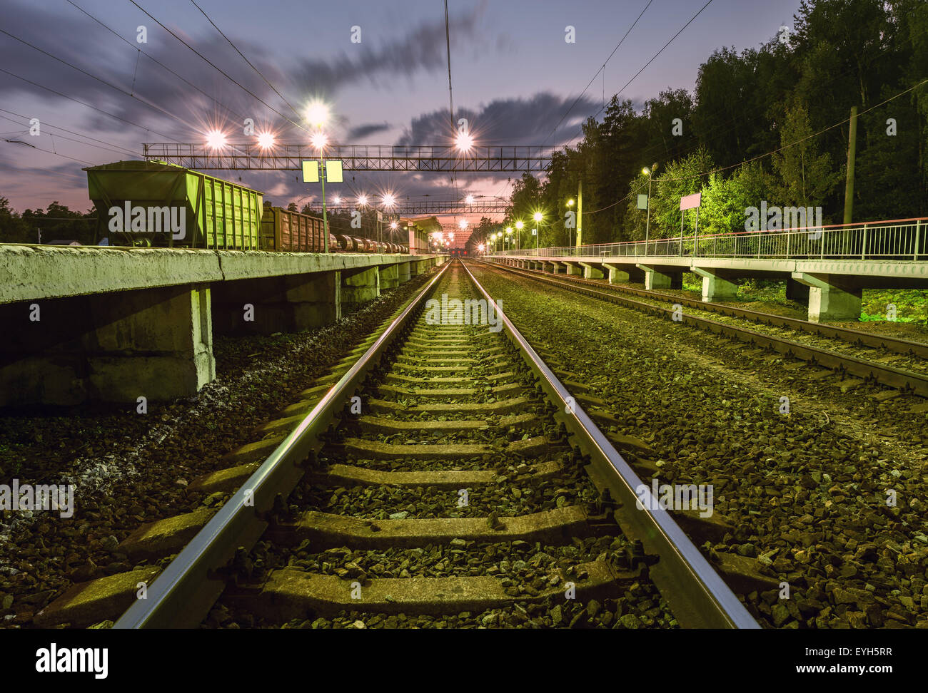 Passenger platforms and freight train on the early morning station ...