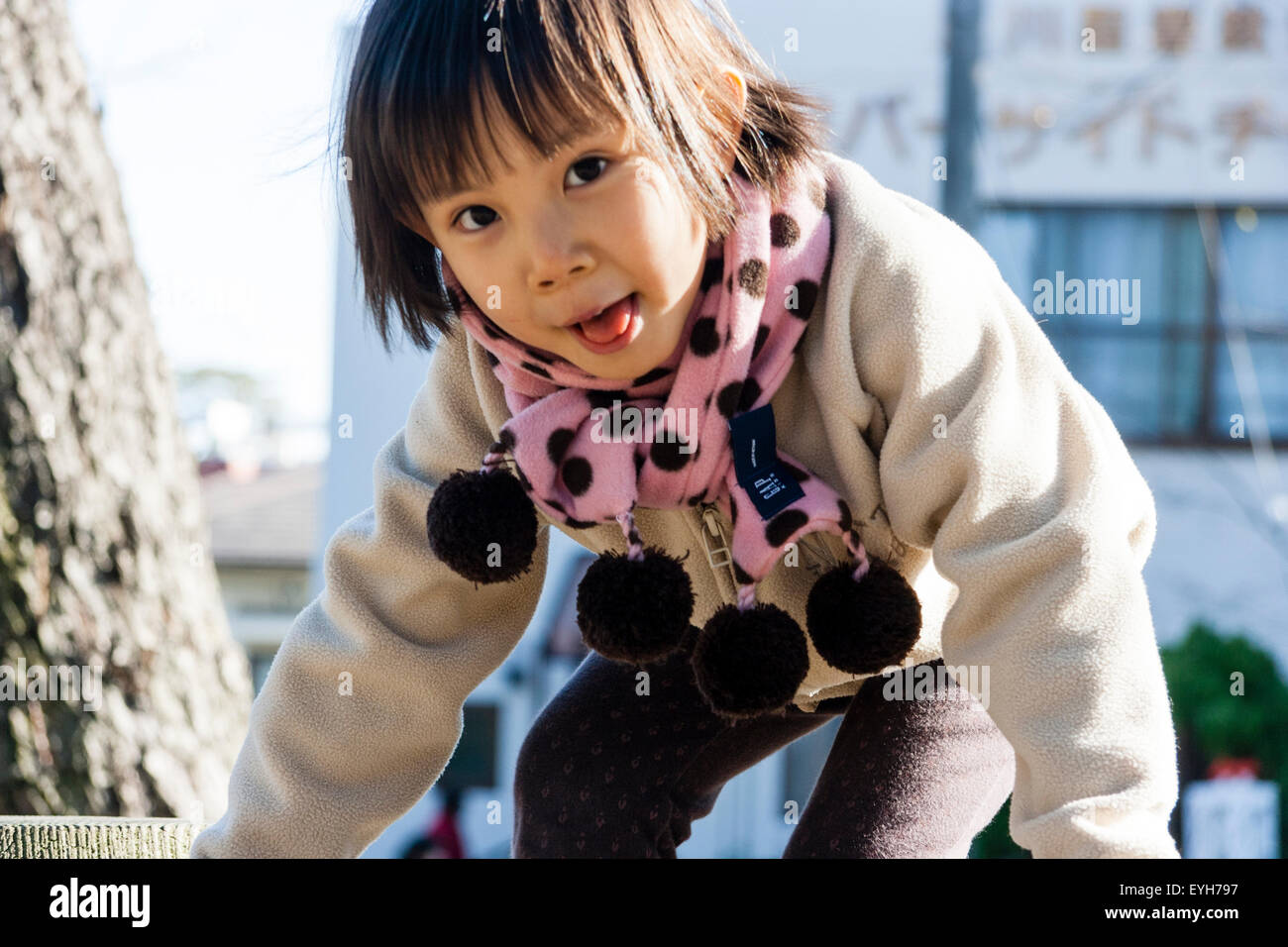 Japanese girl, head turned to look at viewer, tongue lolling out as she ...