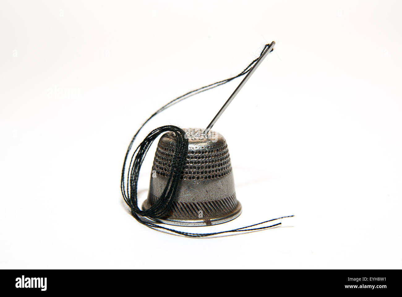Sewing iron Needle and thimble on a white background Stock Photo - Alamy